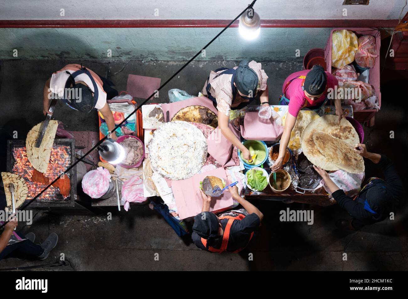 Oaxaca De Juarez, Mexico. 30th Oct, 2021. Women prepare traditional tlayudas at the stand of ...