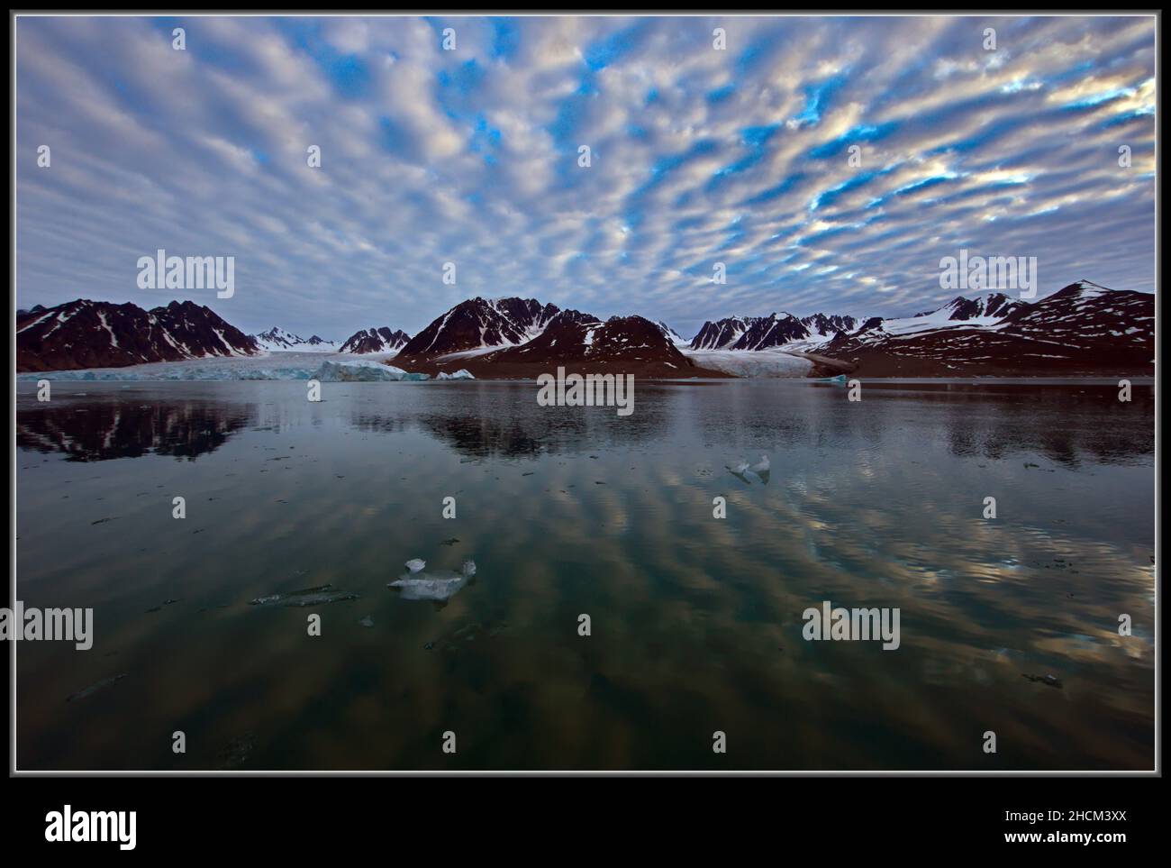 Still waters of the ocean surrounding Svalbard, Norway under beautiful ...