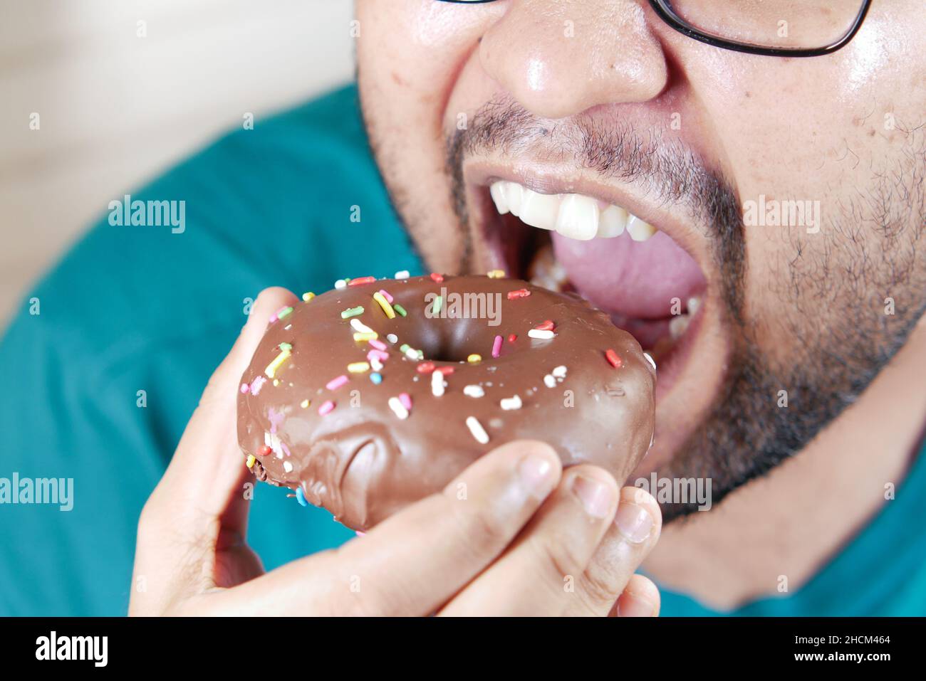 Young man eating donut hi-res stock photography and images - Alamy