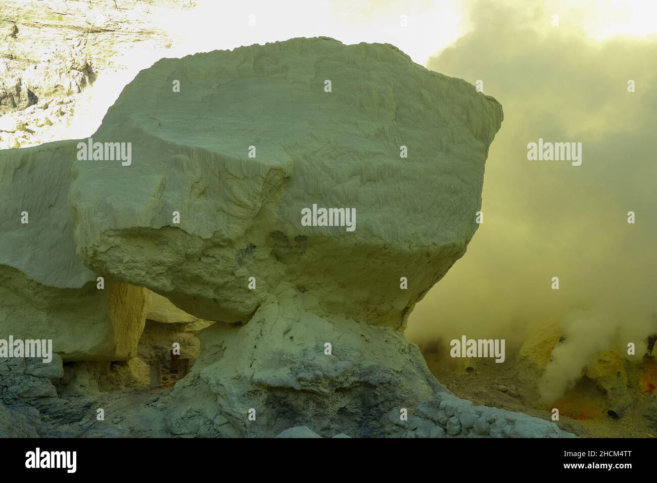 Lava rock covered in monoclinic sulphur crystals on a black reflective ...