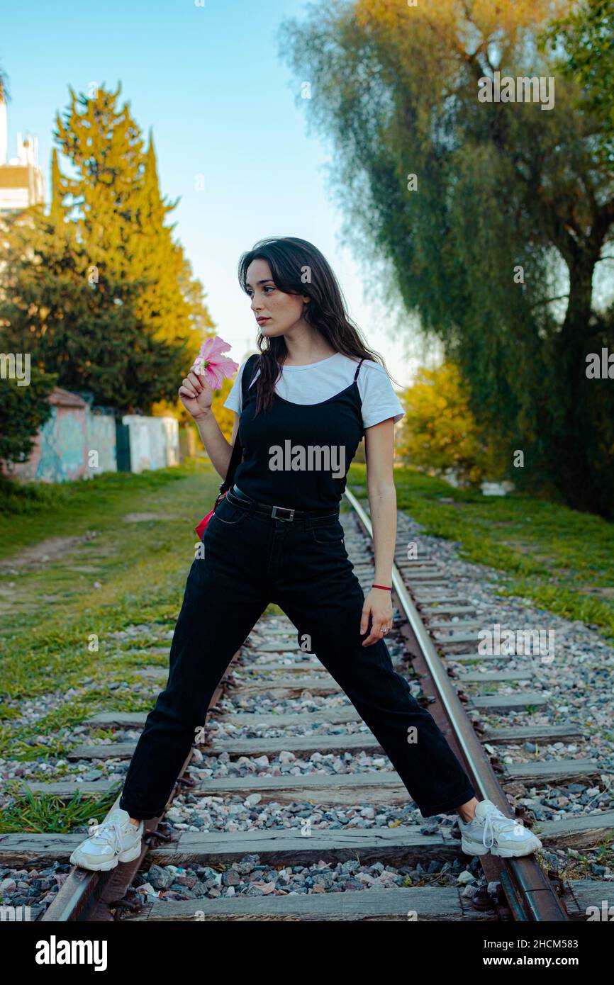 Vertical shot of a young beautiful female posing on train tracks Stock ...