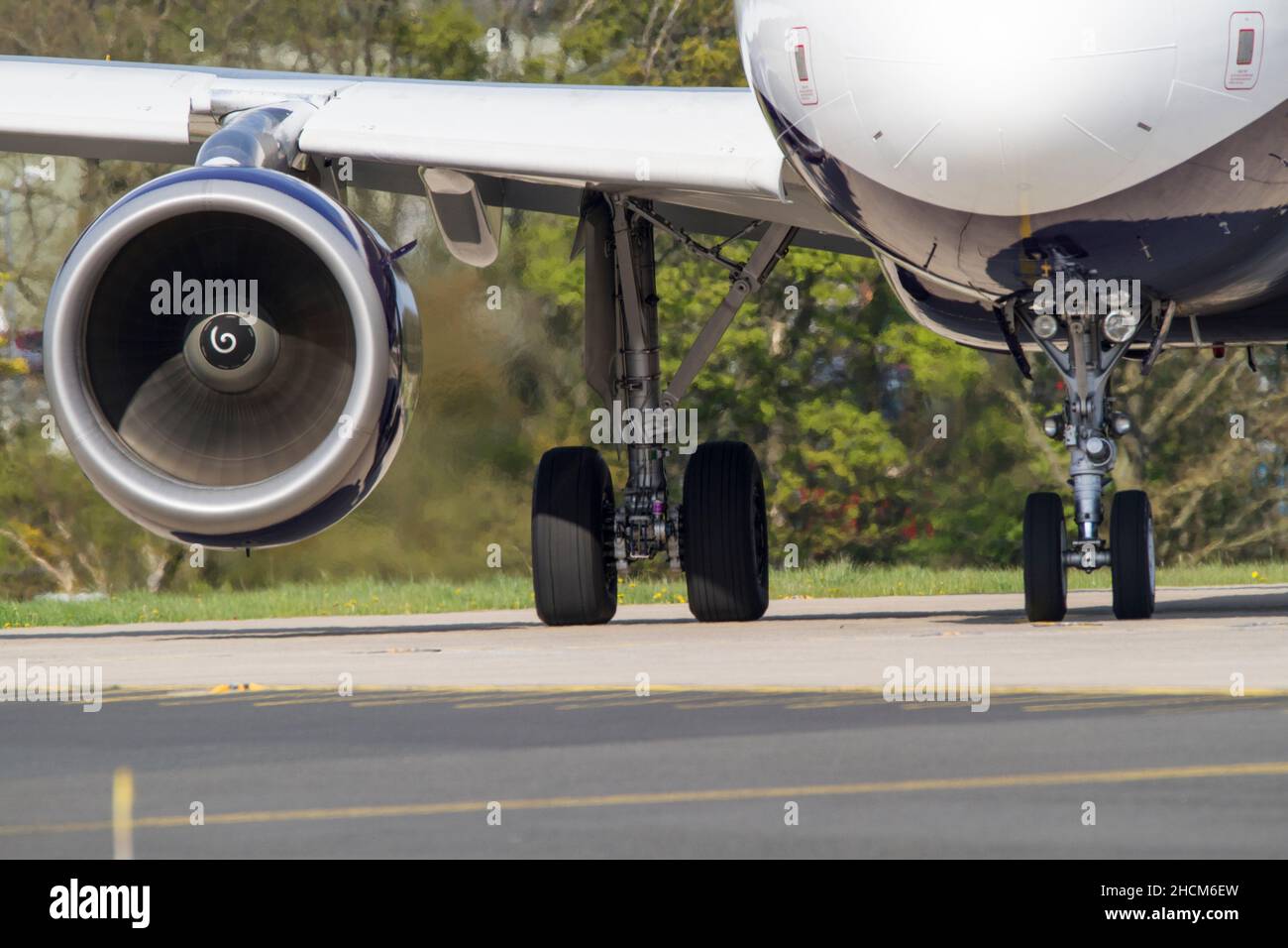 View of a Jet engine at the airport runway with trees in the background ...
