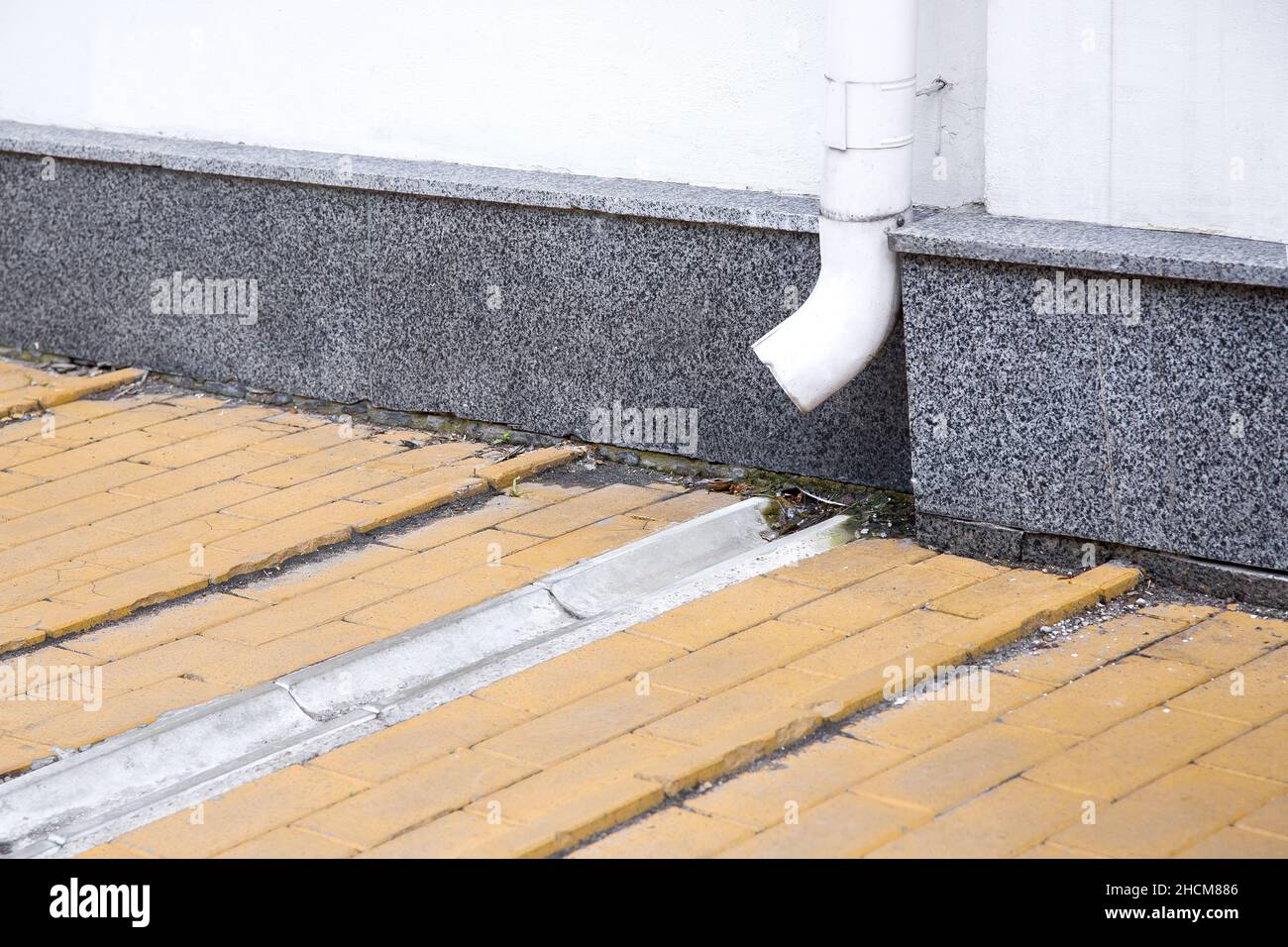 facade of a building wall with a white drainage pipe and a concrete ...