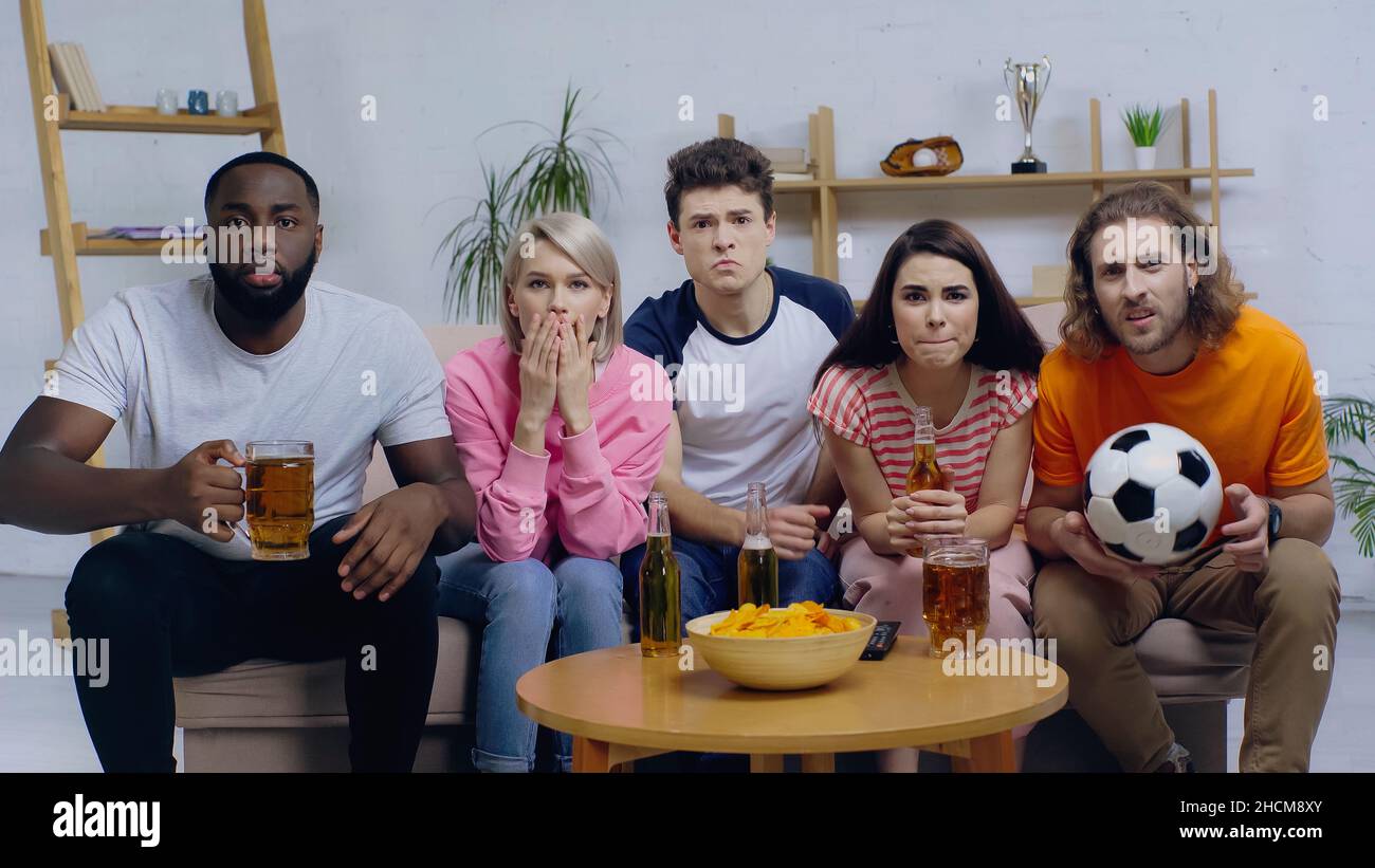 Worried multiethnic friends watching hi-res stock photography and ...