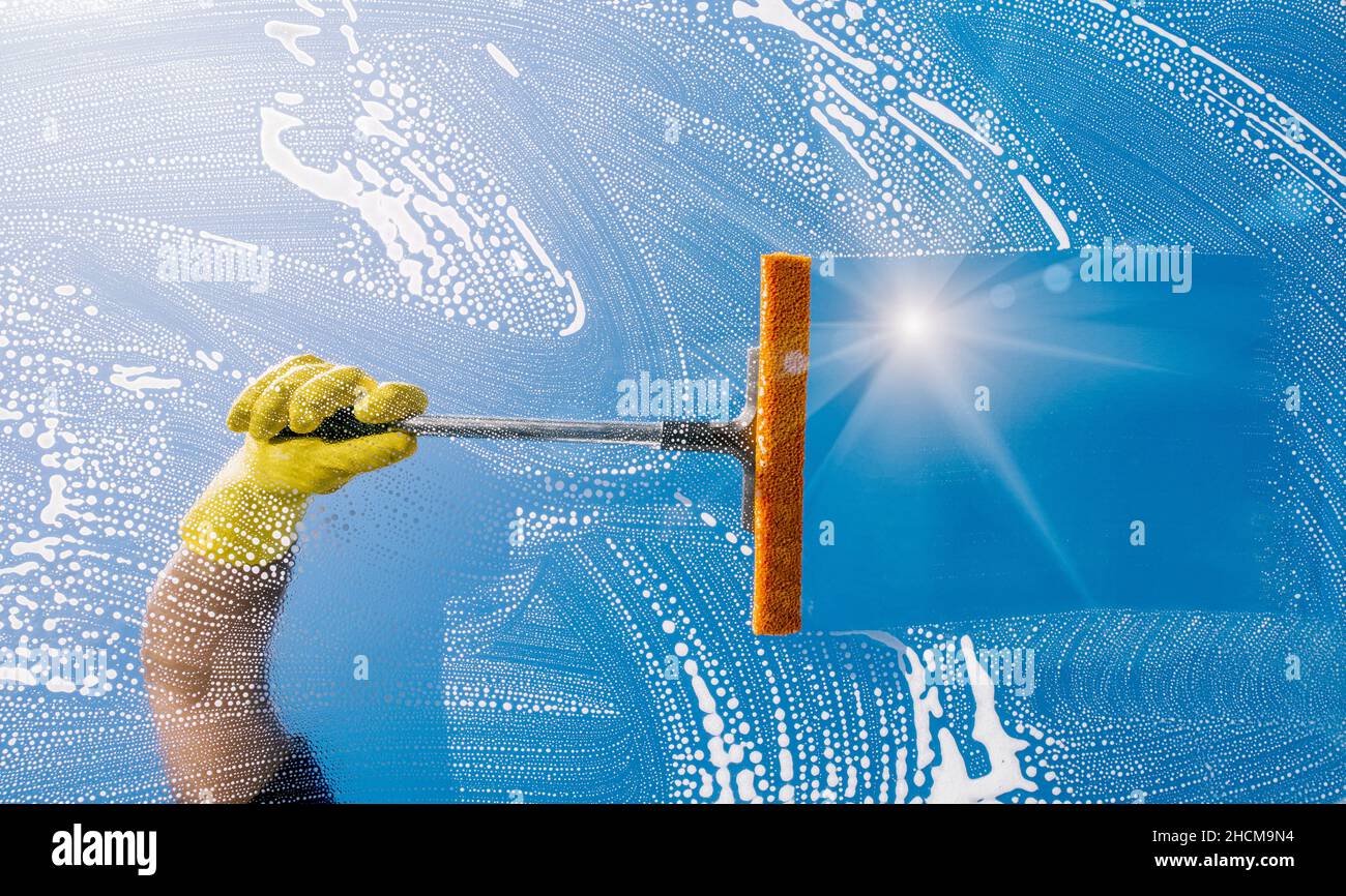 Window cleaner cleans window with puller and foam Stock Photo - Alamy