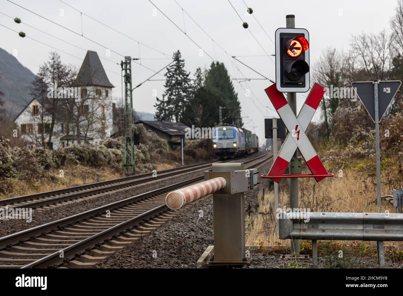 A freight train with an electric locomotive passing a level crossing ...