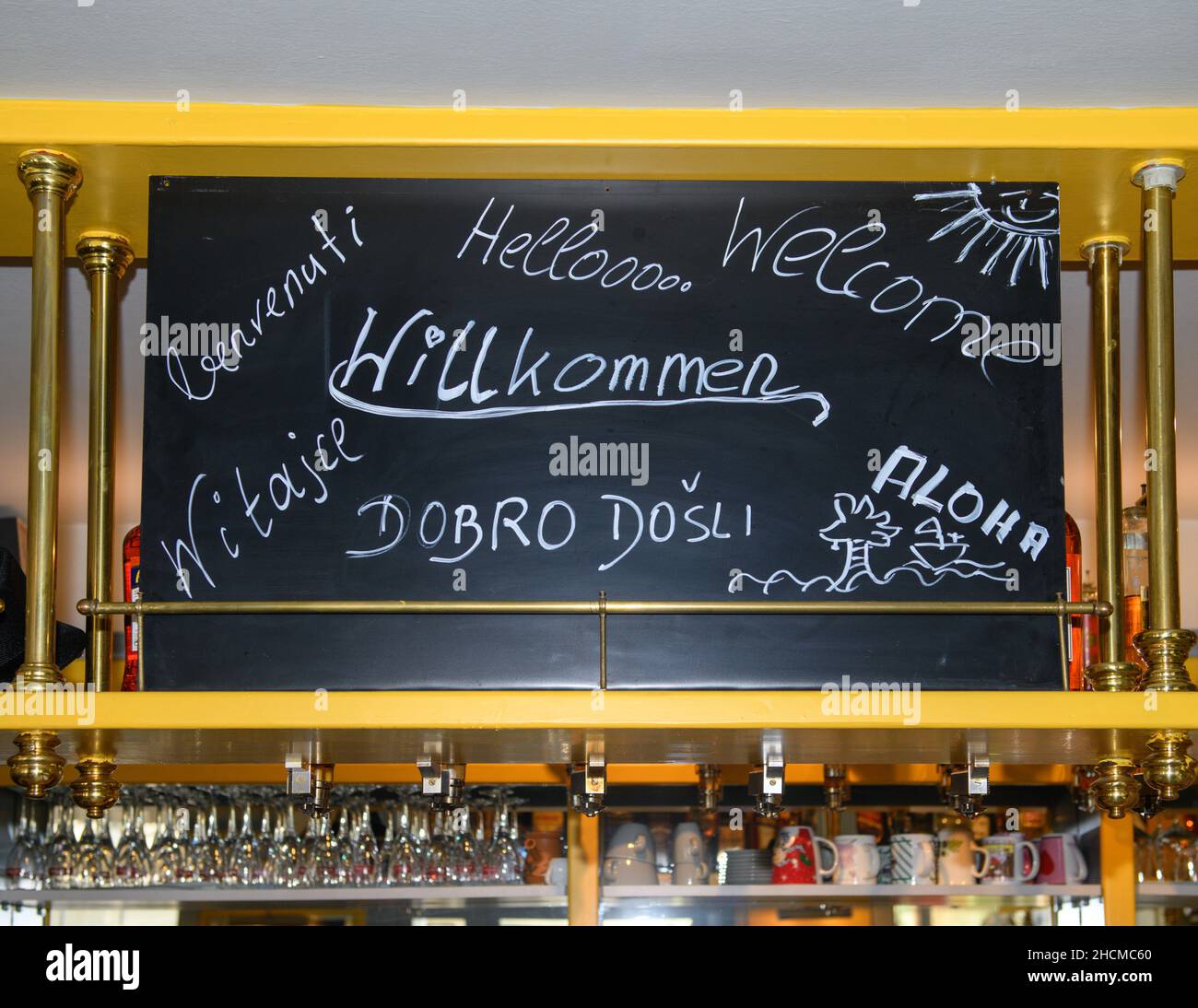 A large hand-lettered notice board that reads "Welcome" in many ...