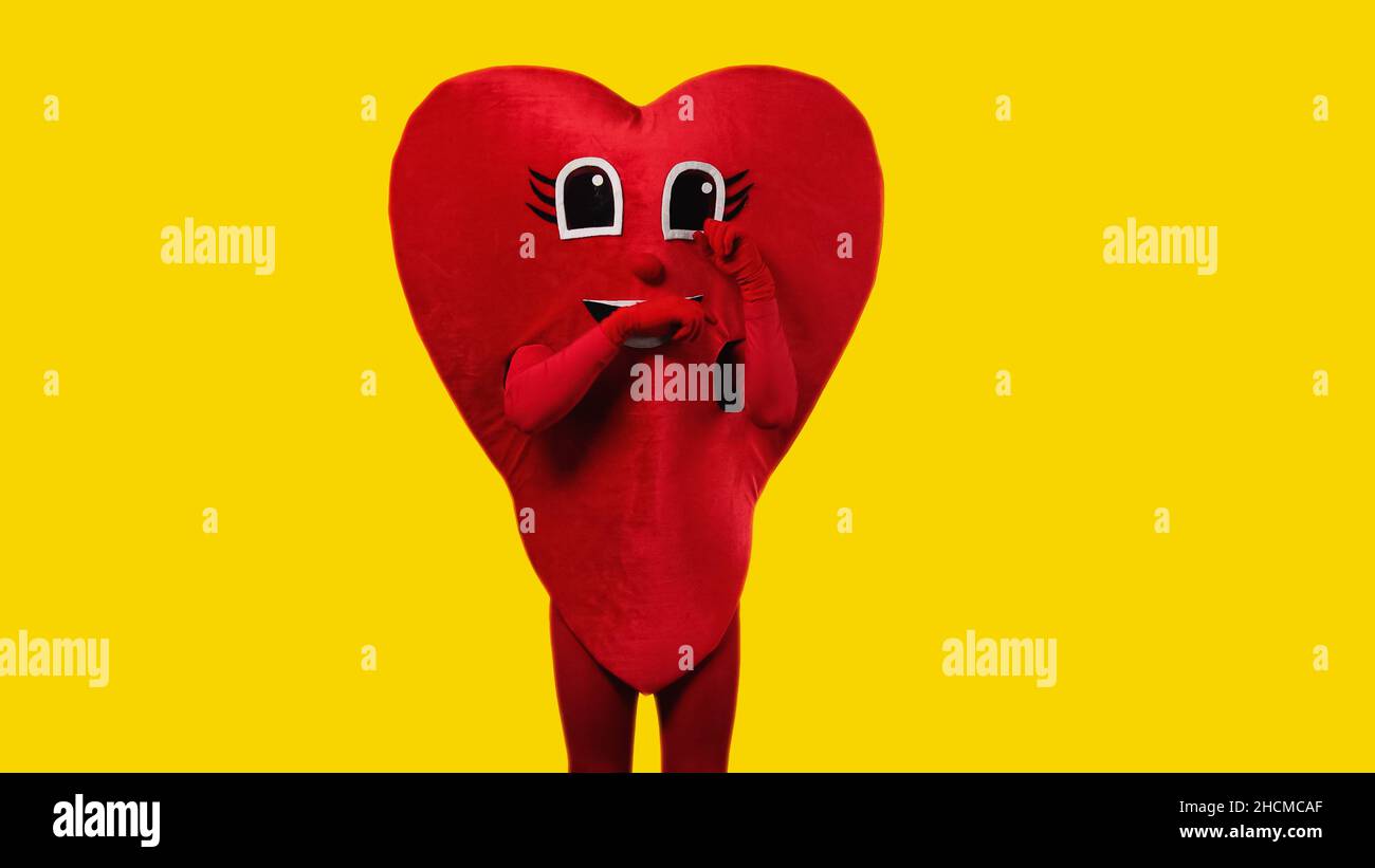 person in red heart costume touching cartoon eyes while imitating ...