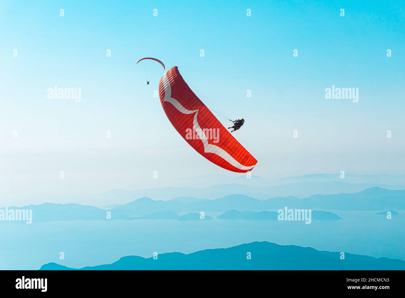 Paragliding in the sky. Paraglider tandem flying over the sea with ...