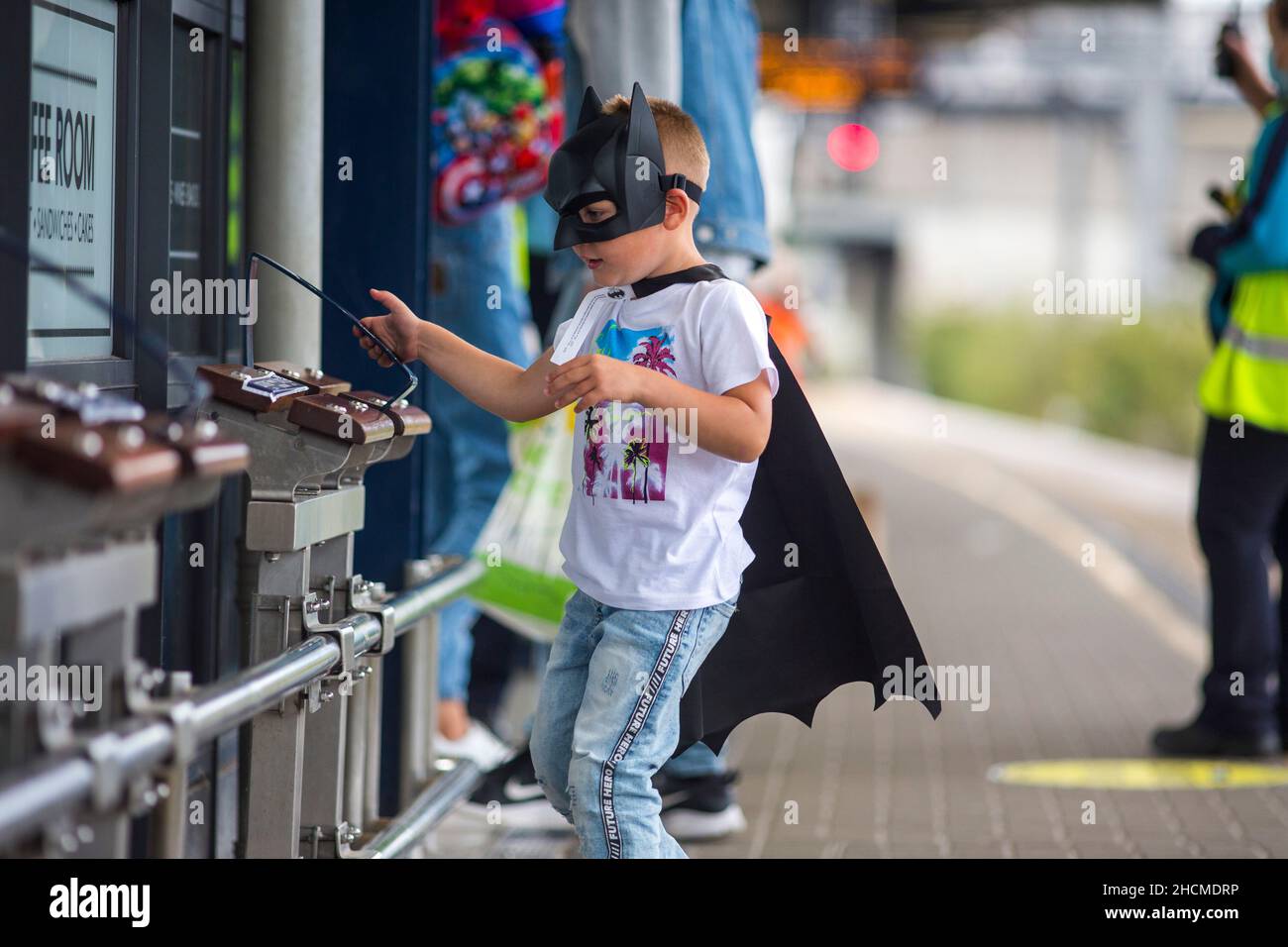 A child dressed as batman plays on a platform in Kent as he waits for a ...