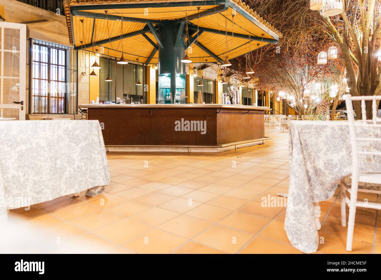 Hexagonal outdoor hotel bar open at night with lights on and tables ...