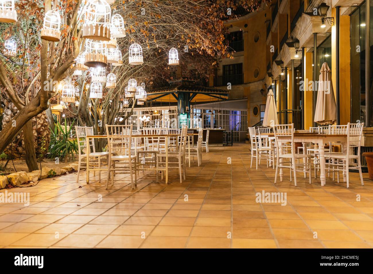 Hotel terrace in an empty courtyard at night with illuminated lanterns ...