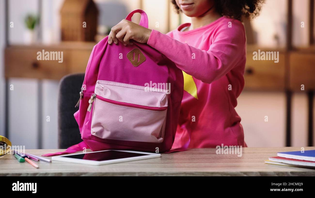partial view of african american child holding packed backpack Stock ...