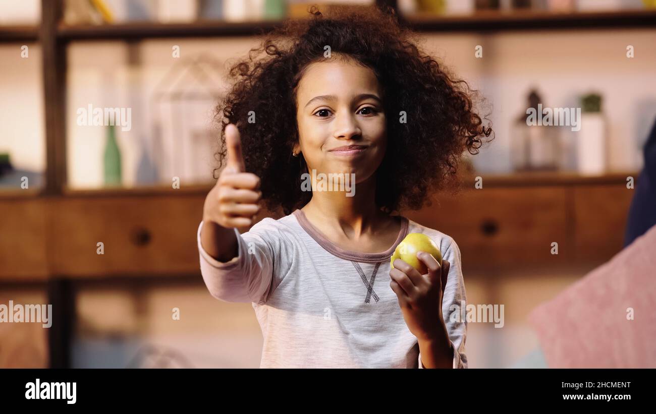 african american child showing thumb up while eating apple Stock Photo ...