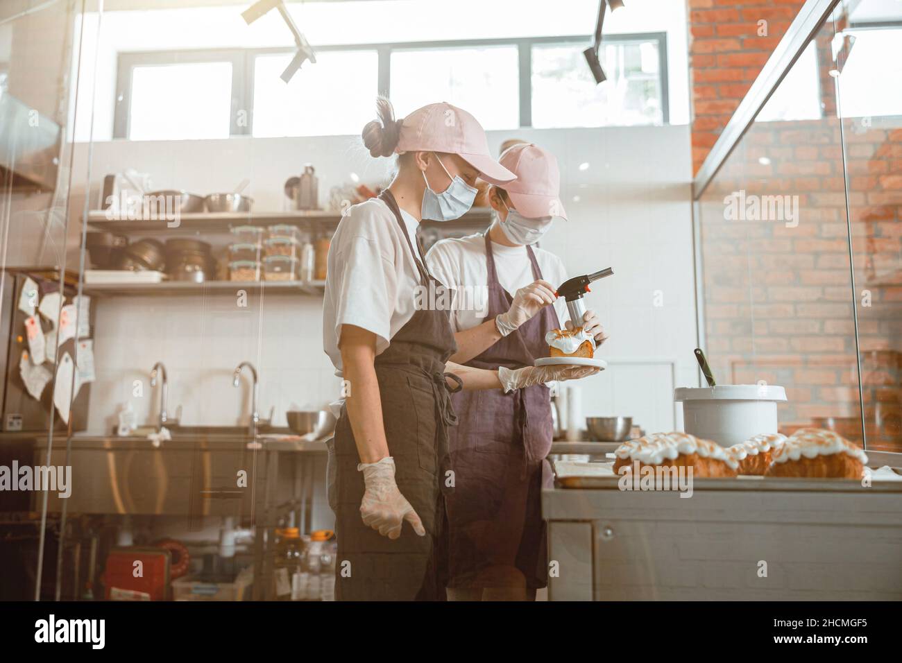 Woman in mask holds cake with burnt cream near colleague with gas ...