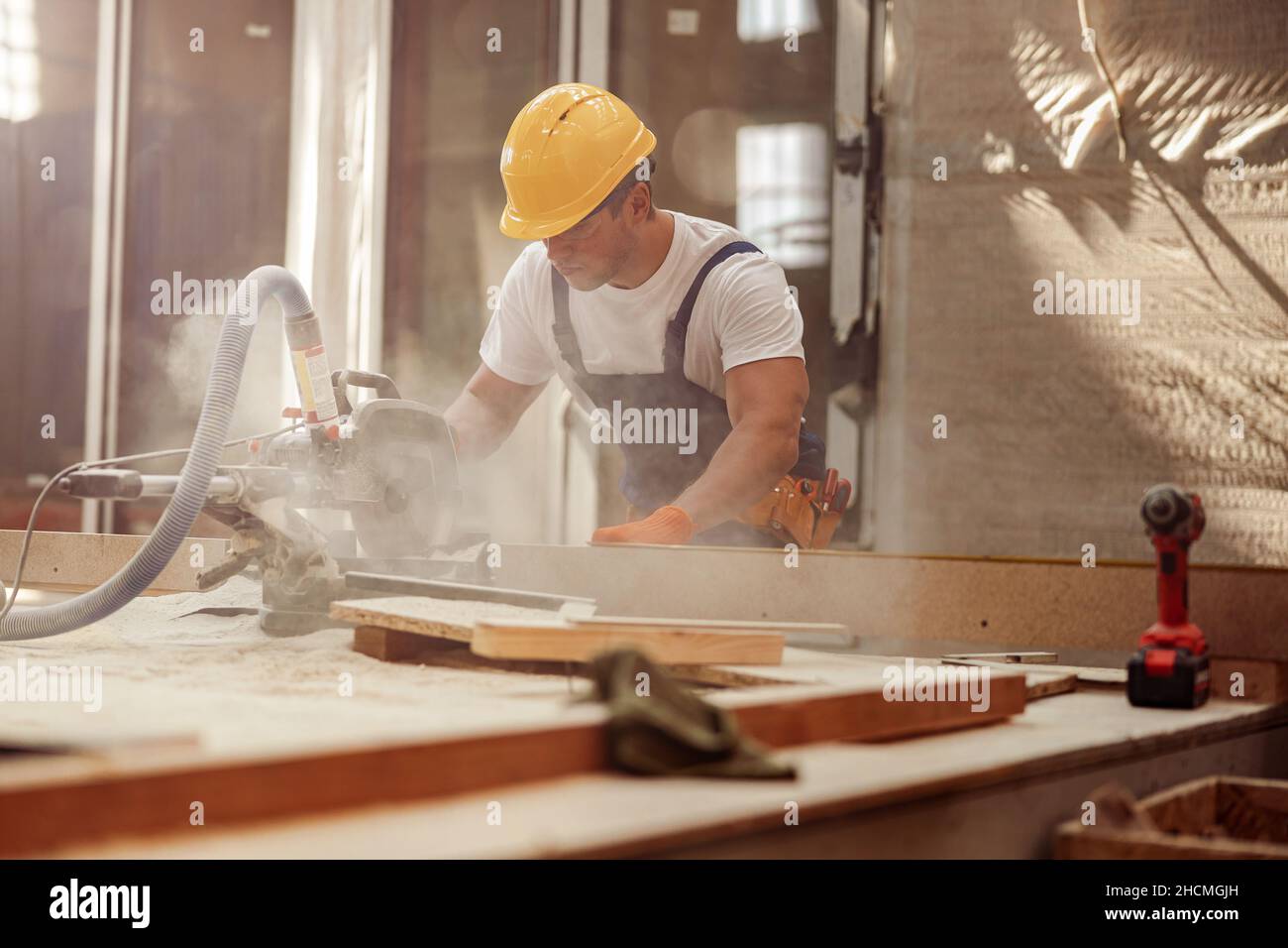 Male worker using wood cutting circular saw machine in workshop Stock ...