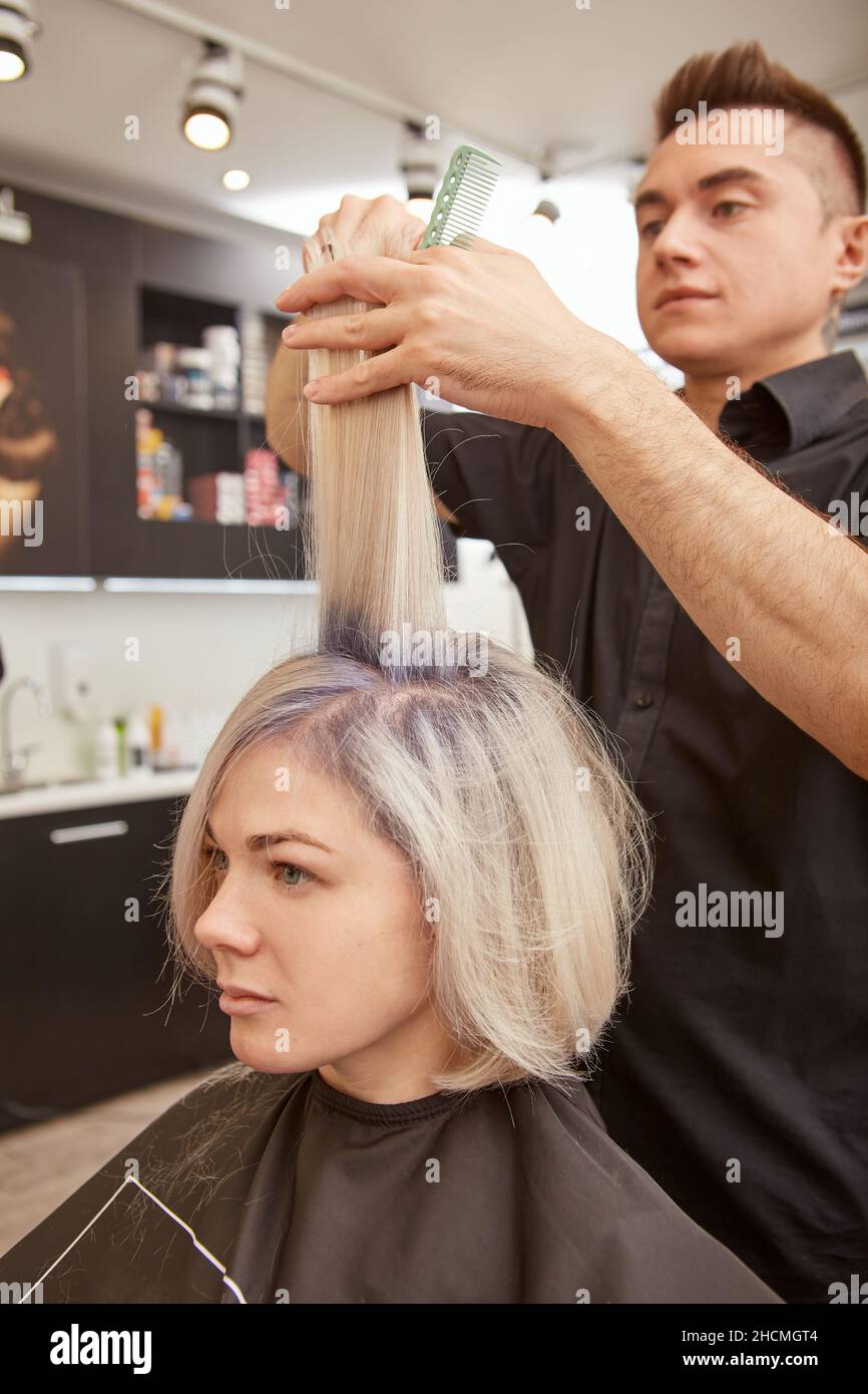 Attractive young woman getting haircut in beauty salon Stock Photo - Alamy