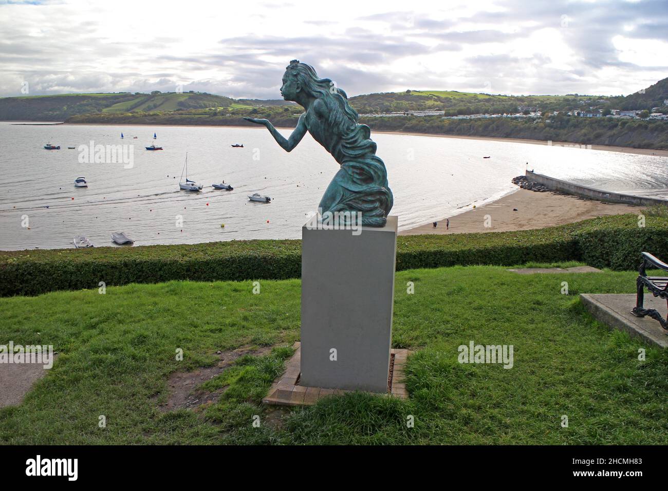 Mermaid statue New Quay seafront with people enjoying themselves on the ...