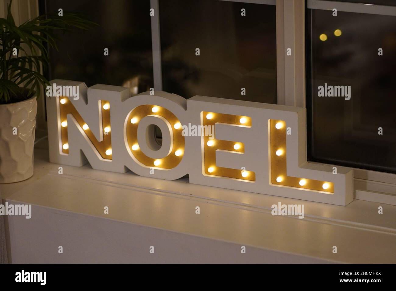 Photo of a lit noel sign decor in front of a window Stock Photo - Alamy