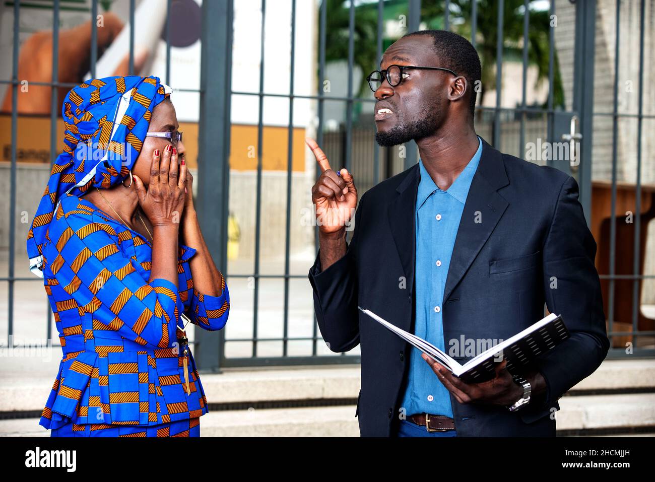 angry businessman holding an open notebook and pointing index finger at ...
