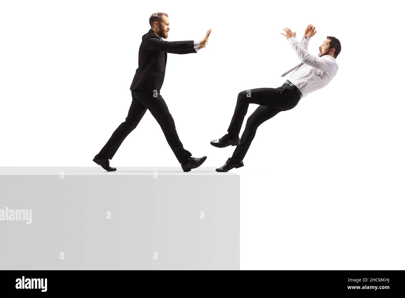 Full length profile shot of a businessman pushing a man from a wall ...