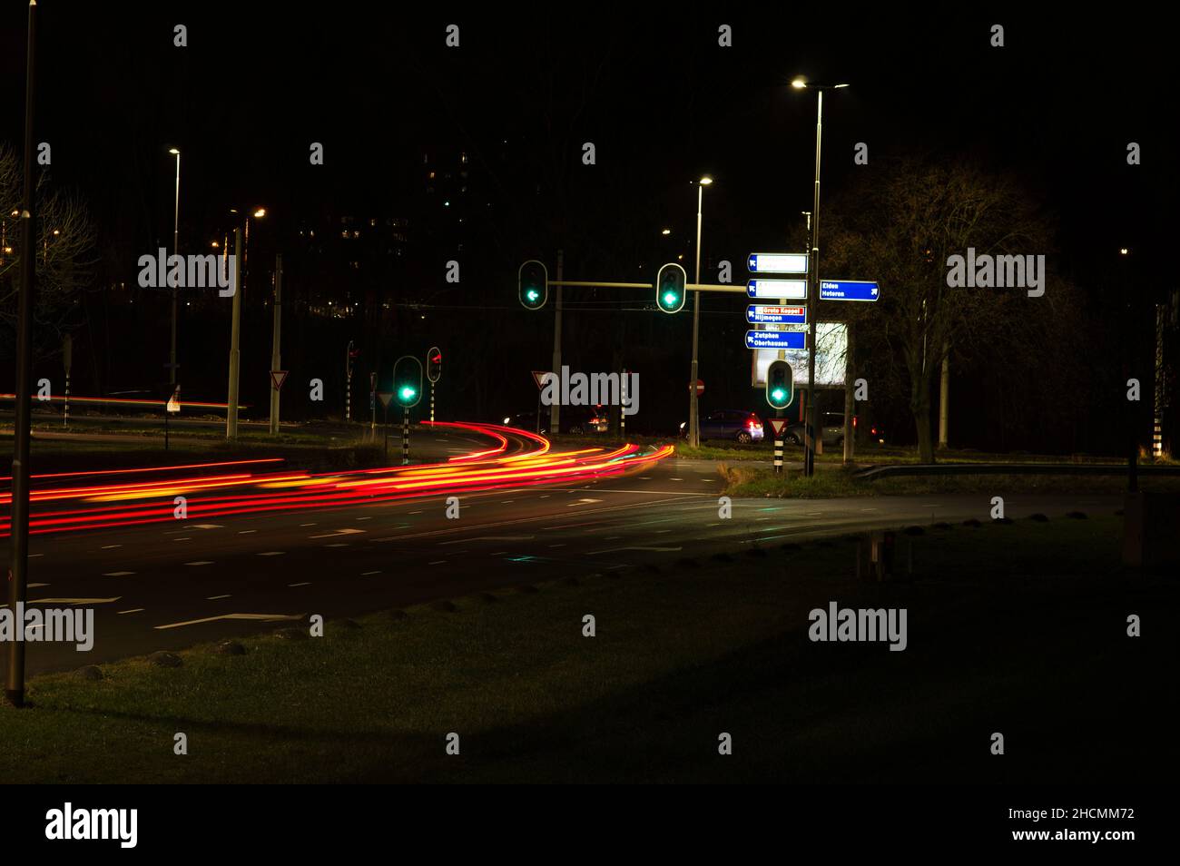 Intersection at night with traffic lights and traffic blurred by motion ...
