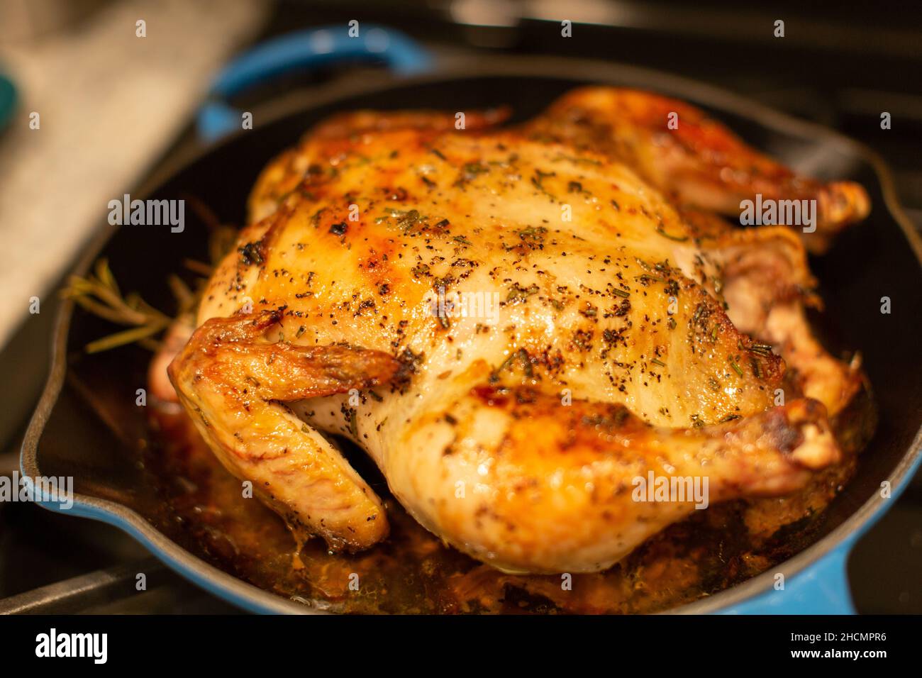 Closeup of the whole seasoned chicken being roasted in the pan Stock ...