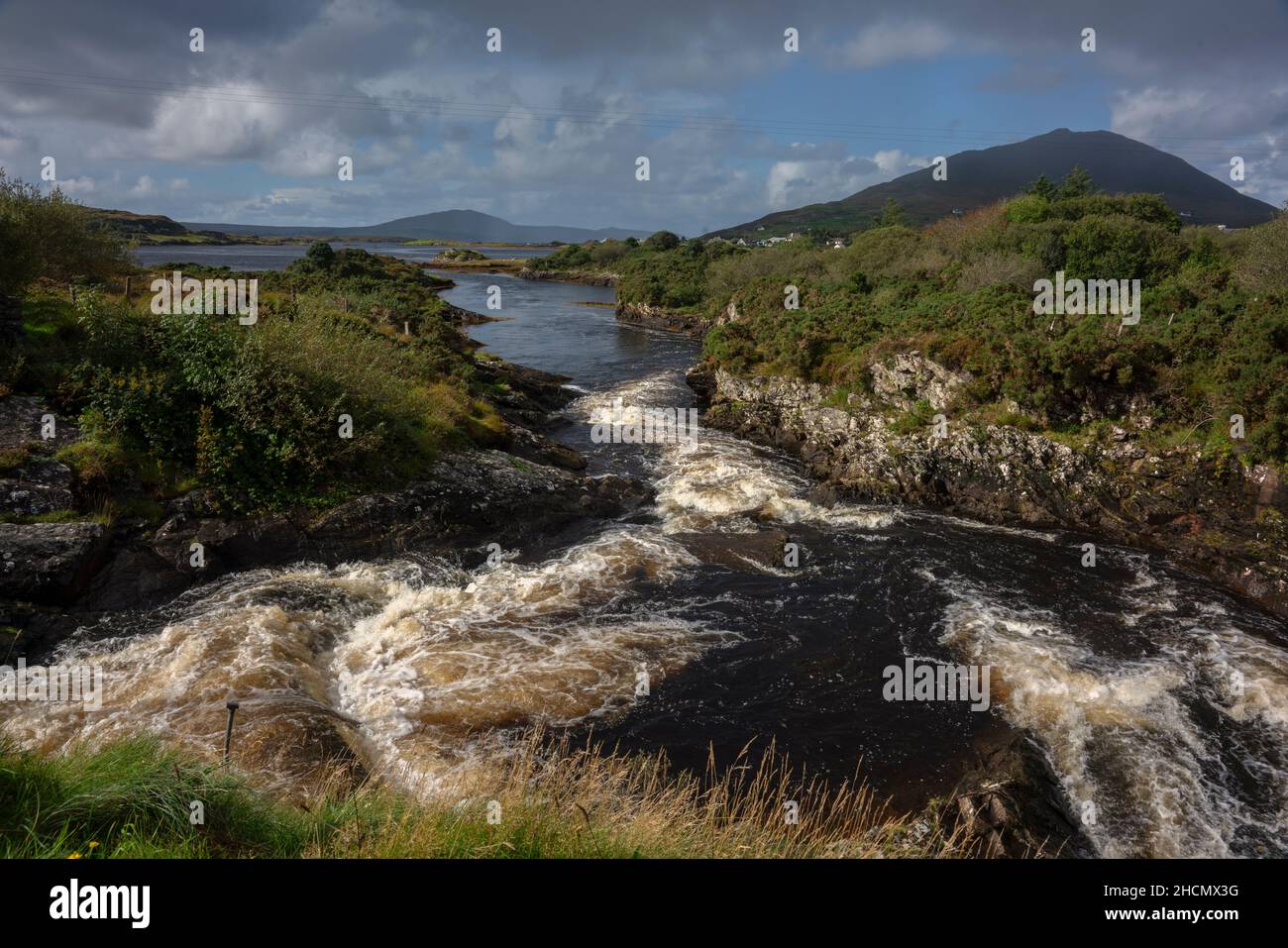 The foaming water of the river flows wild into the sea at Connemara ...