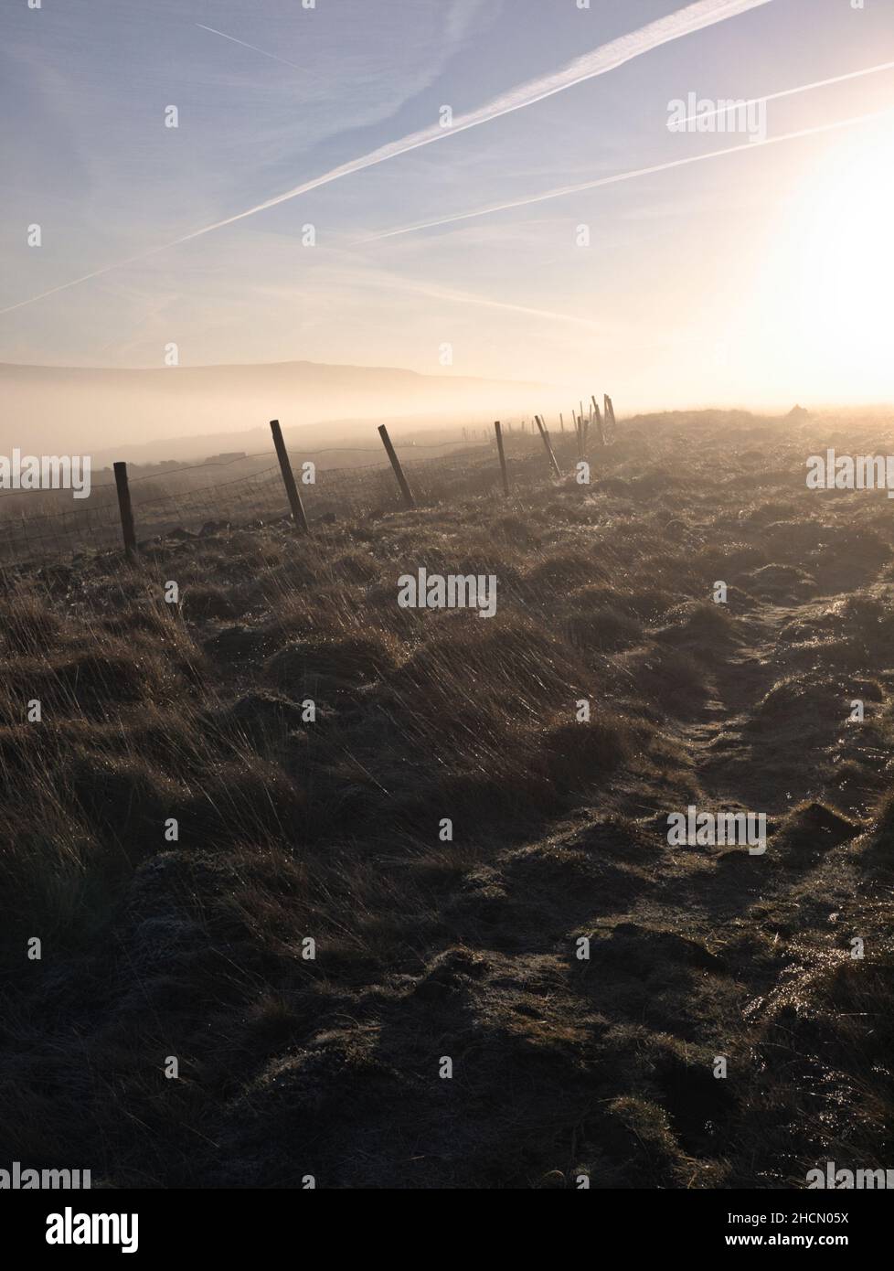 Wire fence line in mist against the winter sun towards Wessenden Valley ...