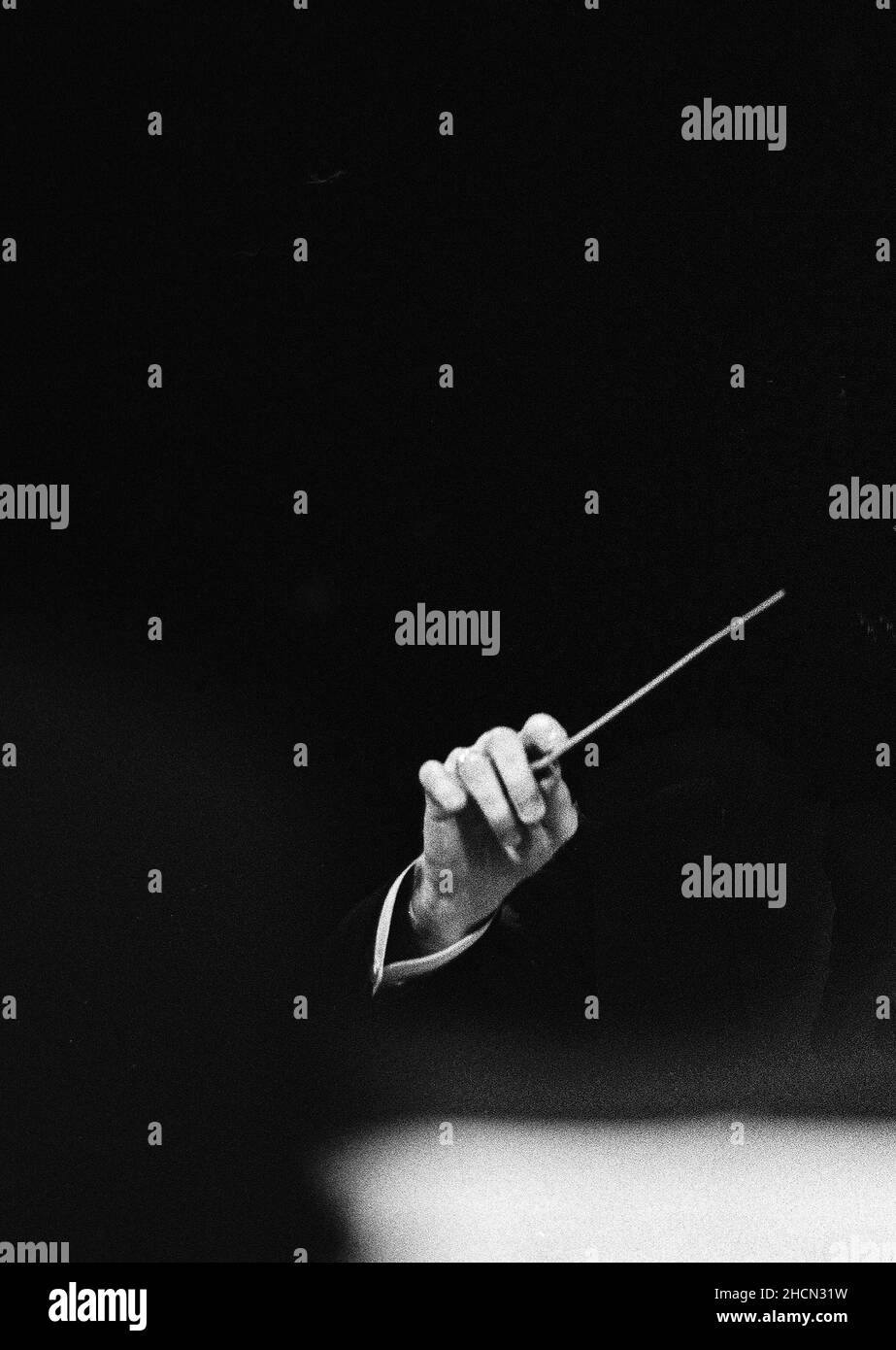 Close up of orchestra conductor, hand isolated on black and copy space ...