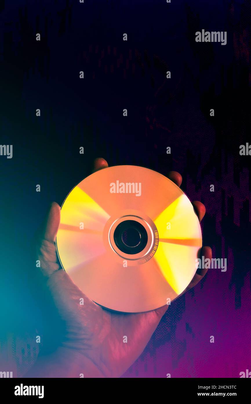 Hand holding compact disc (CD) with vibrant neon colours Stock Photo ...