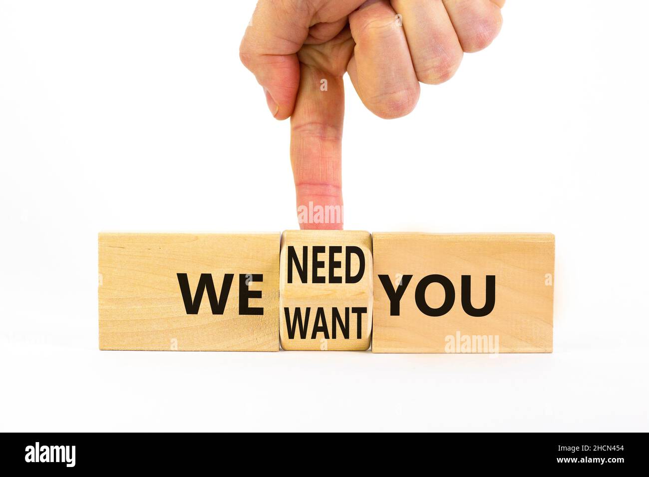 We want and need you symbol. Businessman turns the wooden cube and ...