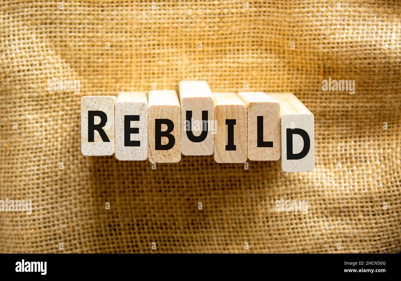 Rebuild and build symbol. The concept word Rebuild on wooden blocks ...