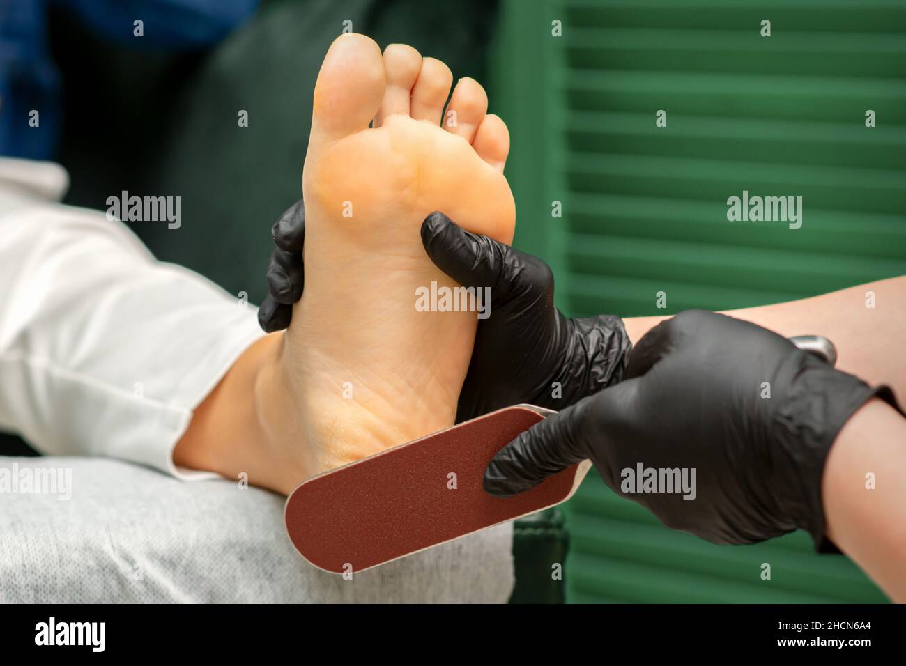 Peeling of Heels. Hands of pedicure master scrape dead from heel skin ...