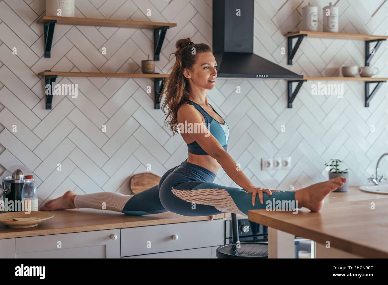 Girl Doing Front Split Between Two Tables In The Kitchen Stock Photo Alamy