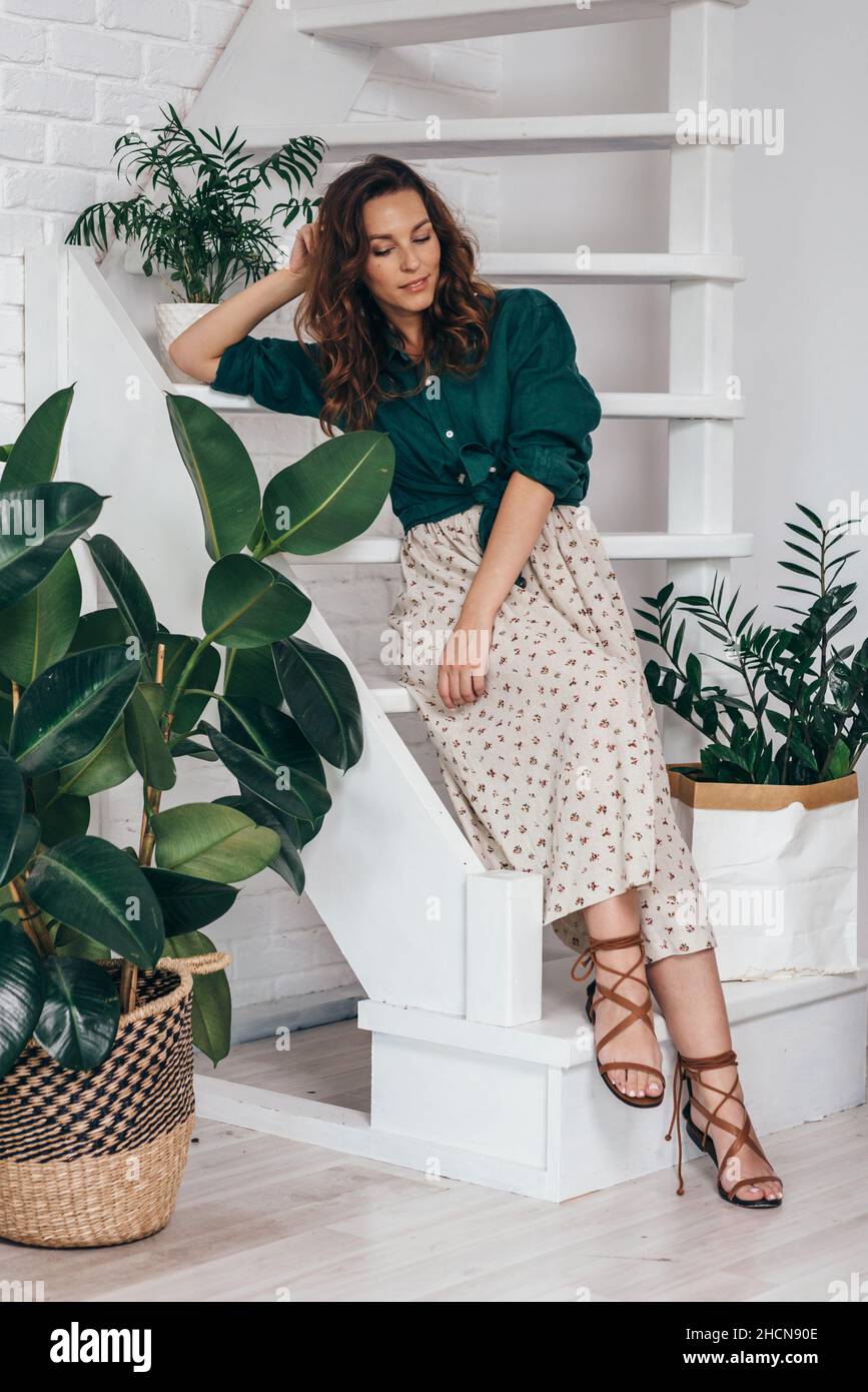Portrait of young woman sitting on stairs at home Stock Photo - Alamy