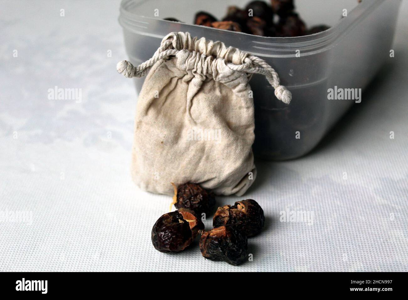 Sapindus mukorossi or Indian soapberry. Many soap nuts and cotton bag ...