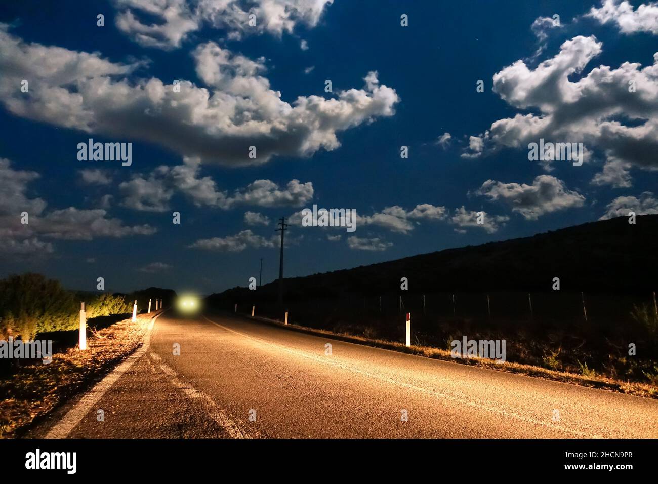 Car lights coming out from the dark - Street by night in the country ...