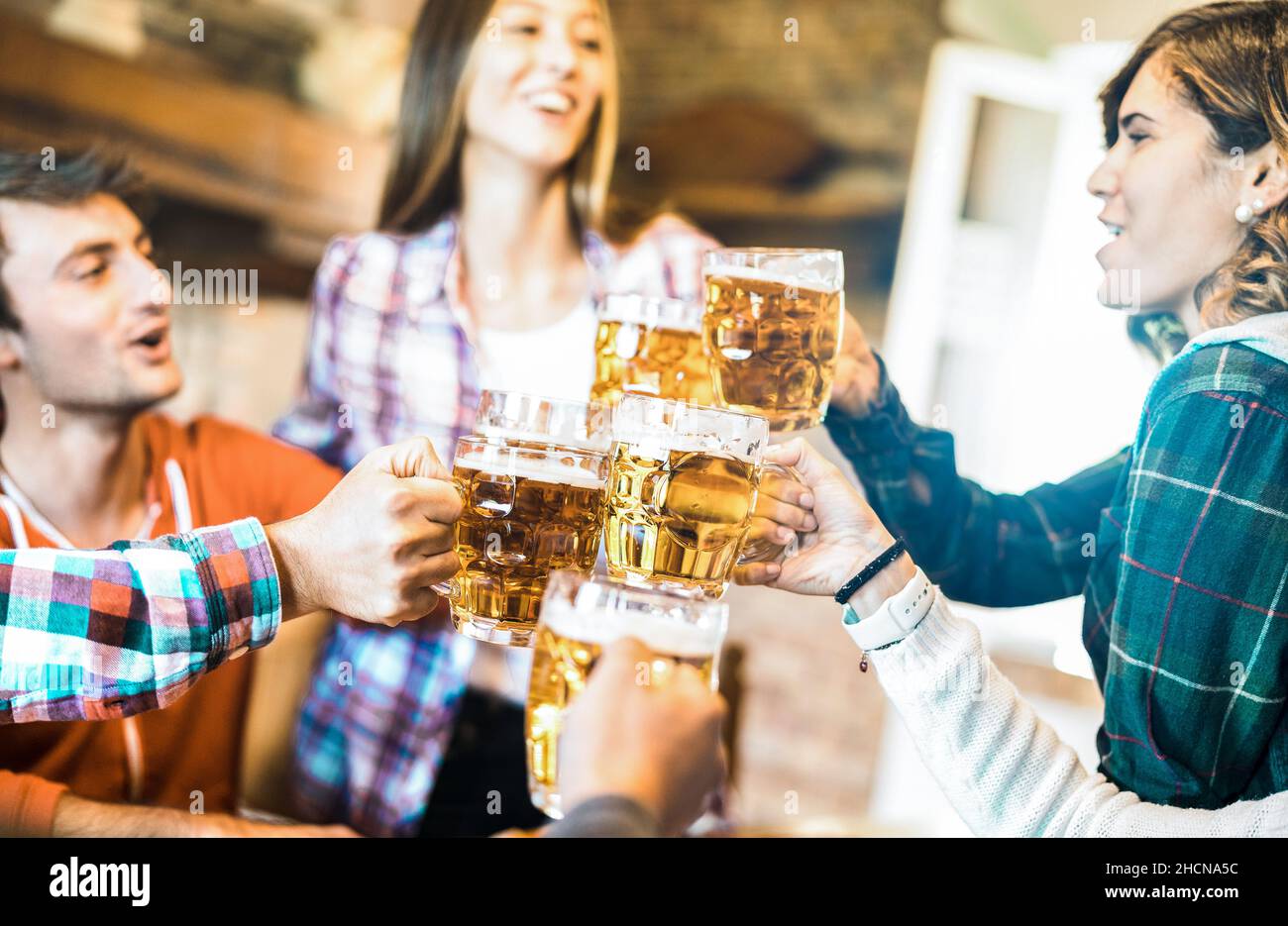 Happy friends group drinking and toasting beer at brewery bar ...