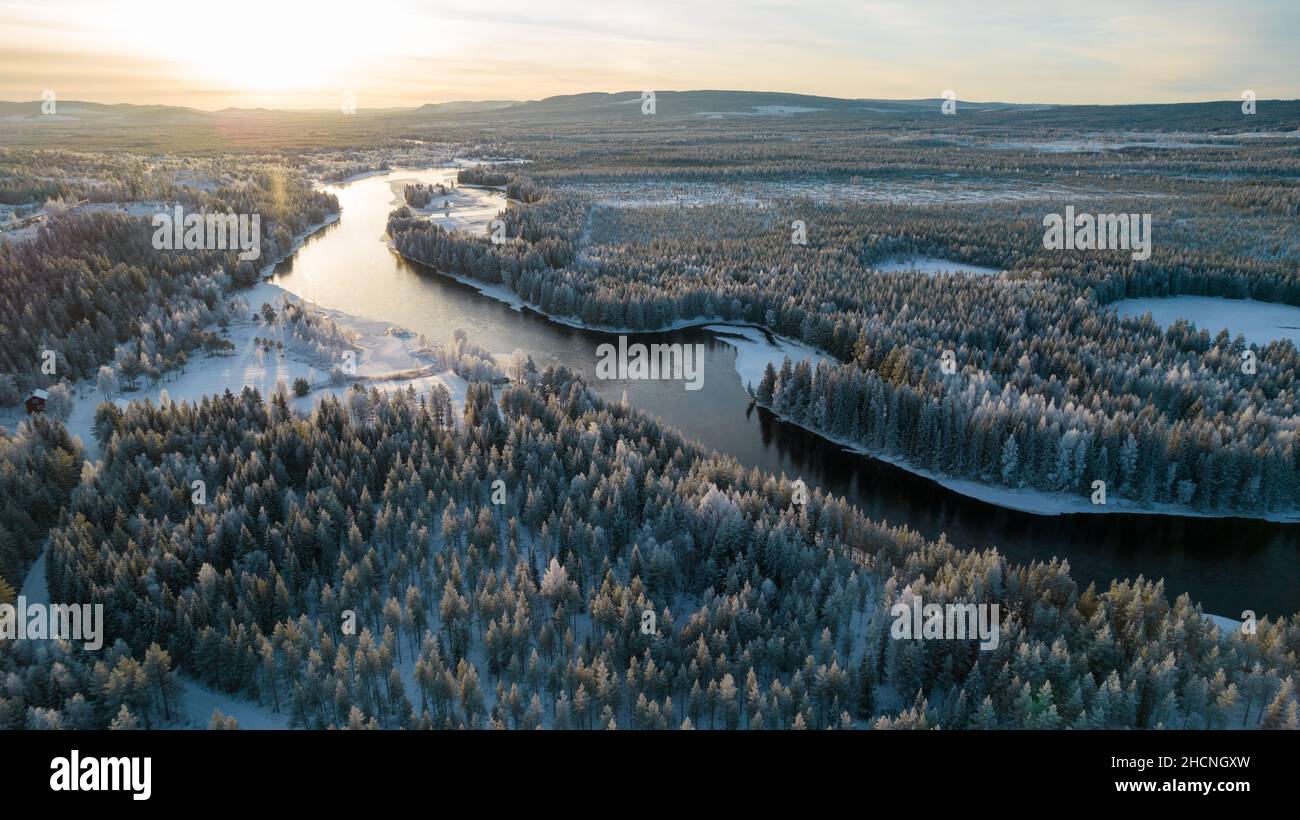 Aerial view of snowy winter forest with black river. Drone photography ...