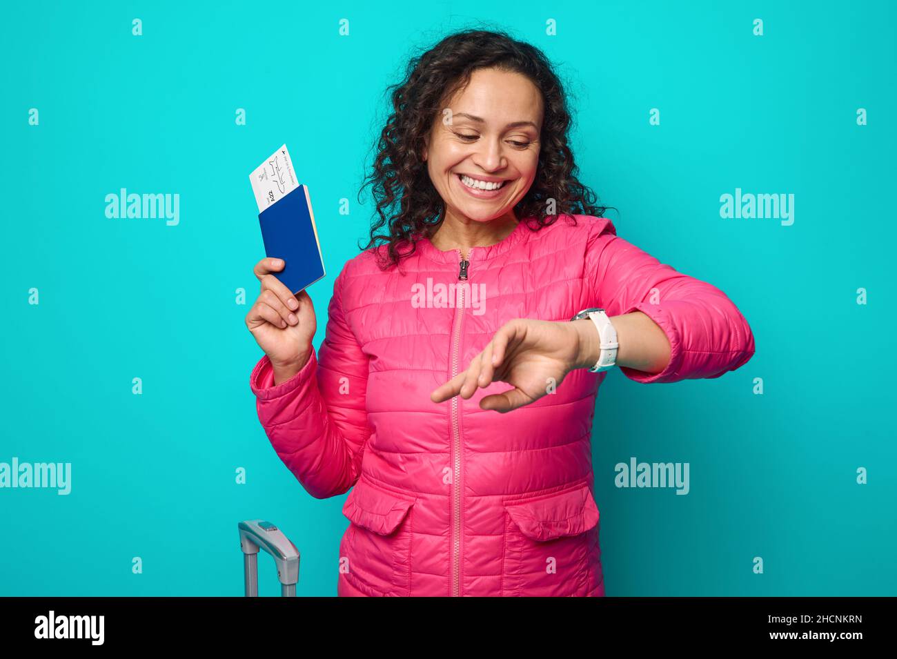 Attractive dark haired pretty woman holding passport and boarding pass ...
