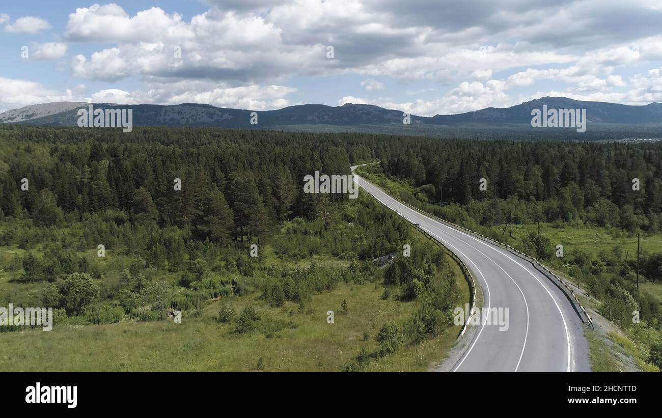 Aerial of the empty road going through forest, summer nature landscape ...