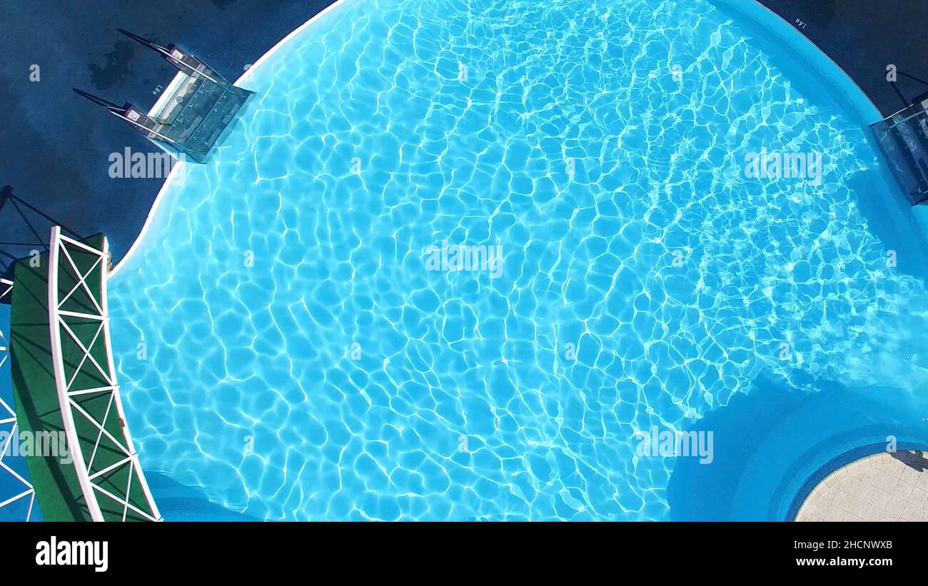 Background of rippled water in swimming pool and wood flooring. Pool ...