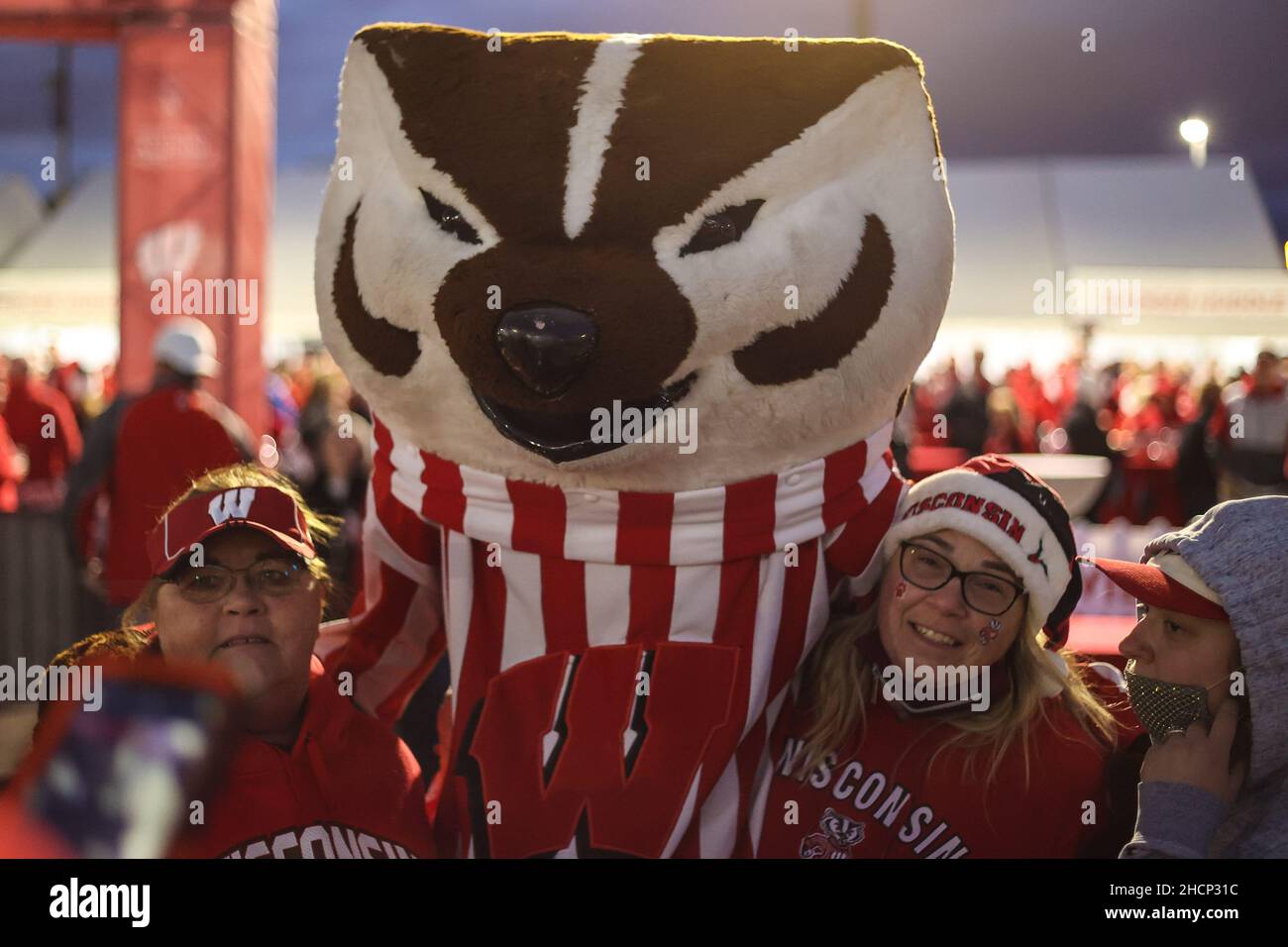 December 30, 2021: Wisconsin fans pose for a quick photo with ''Bucky ...