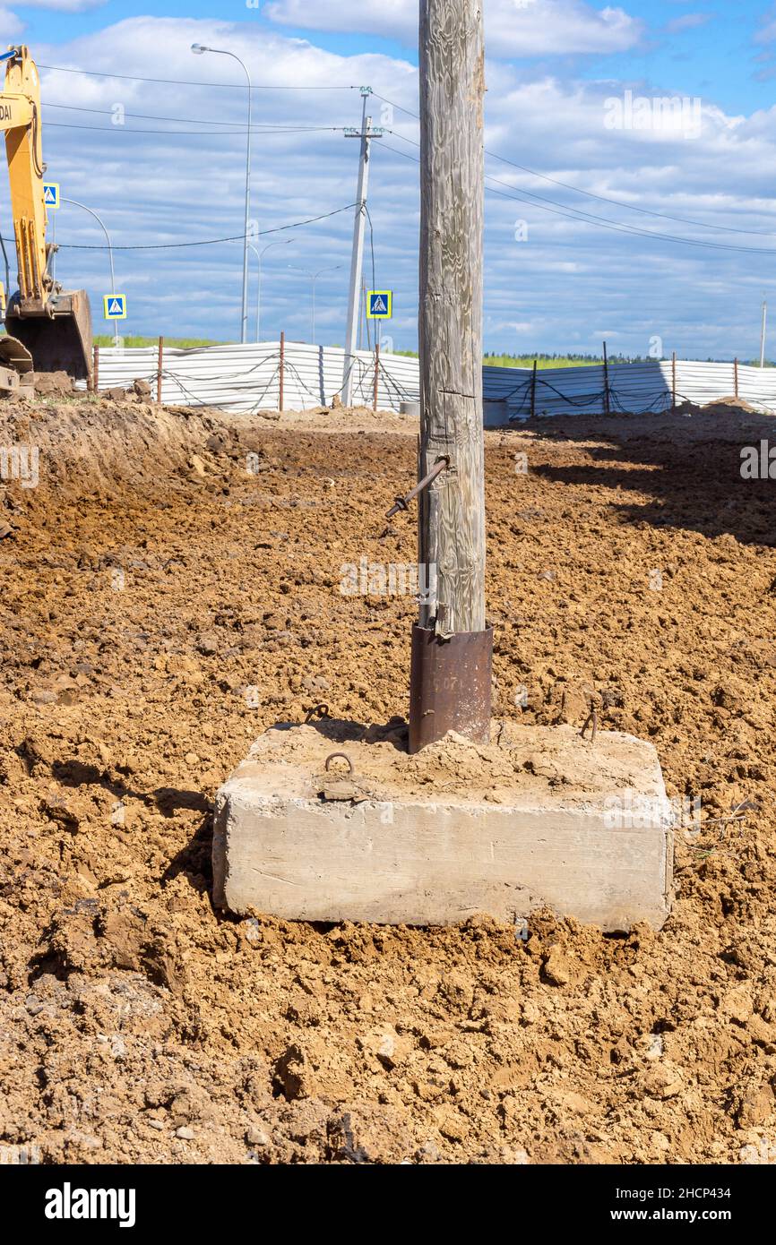 a wooden support for an electrical cable stands in a concrete mobile ...