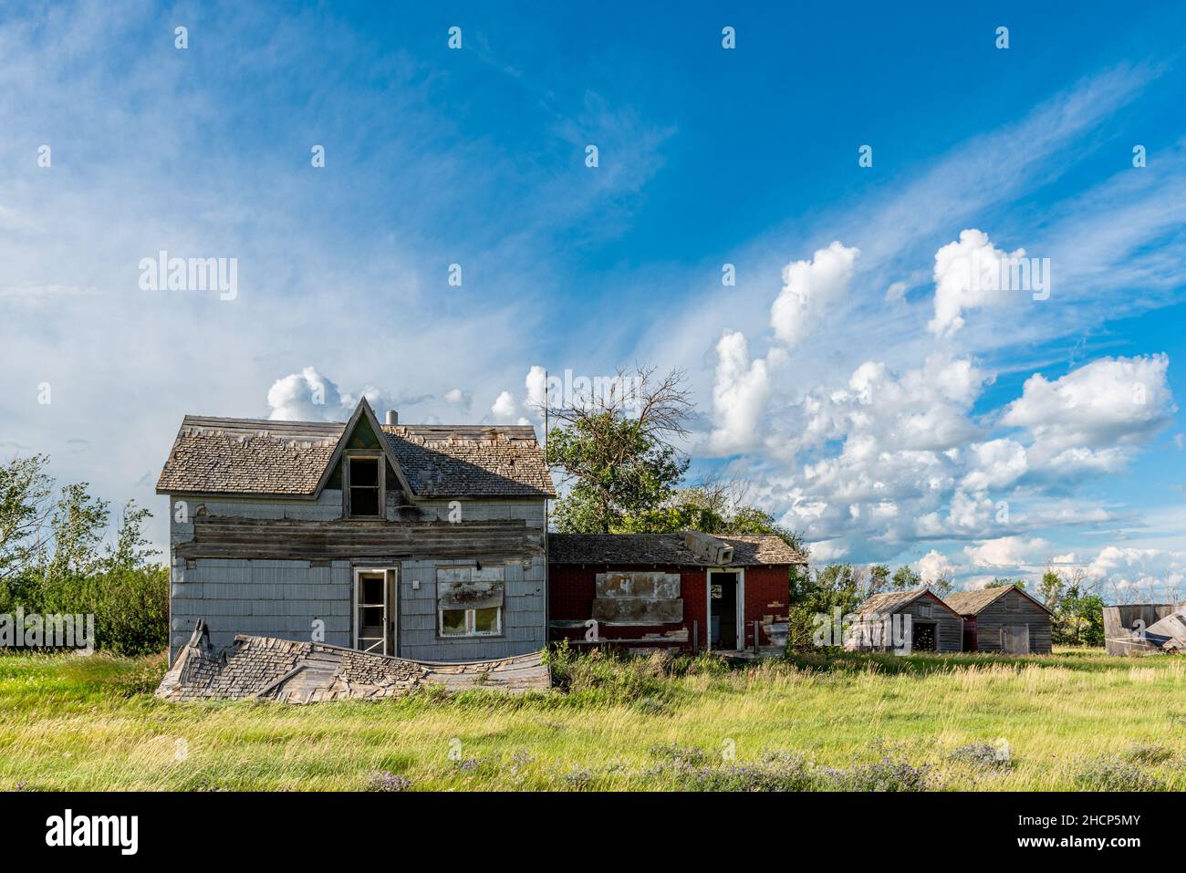 An old, abandoned home and other buildings on the prairies of ...