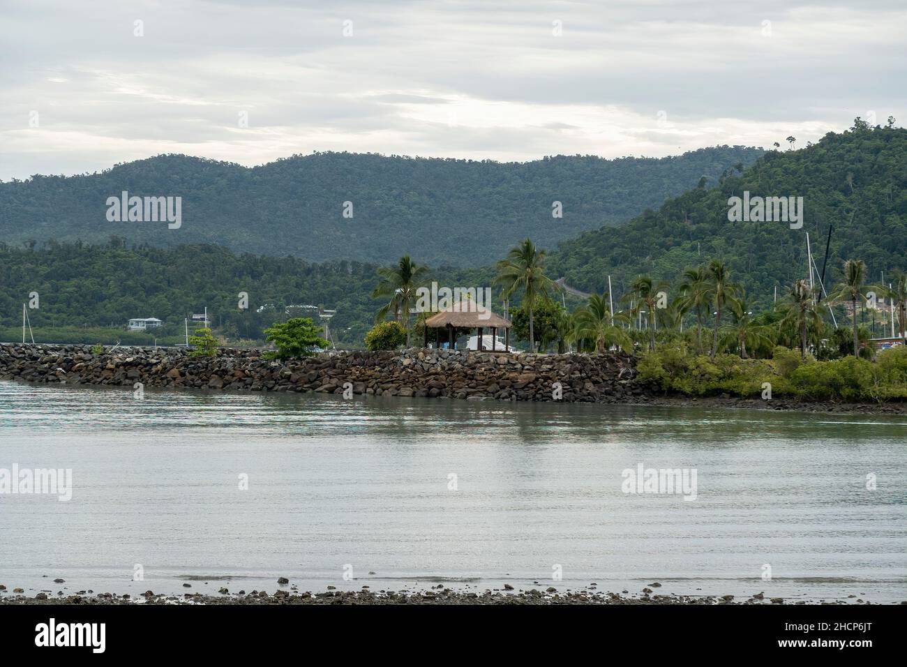 A thatched hut on a man made rock wall inlet on the ocean at low tide ...
