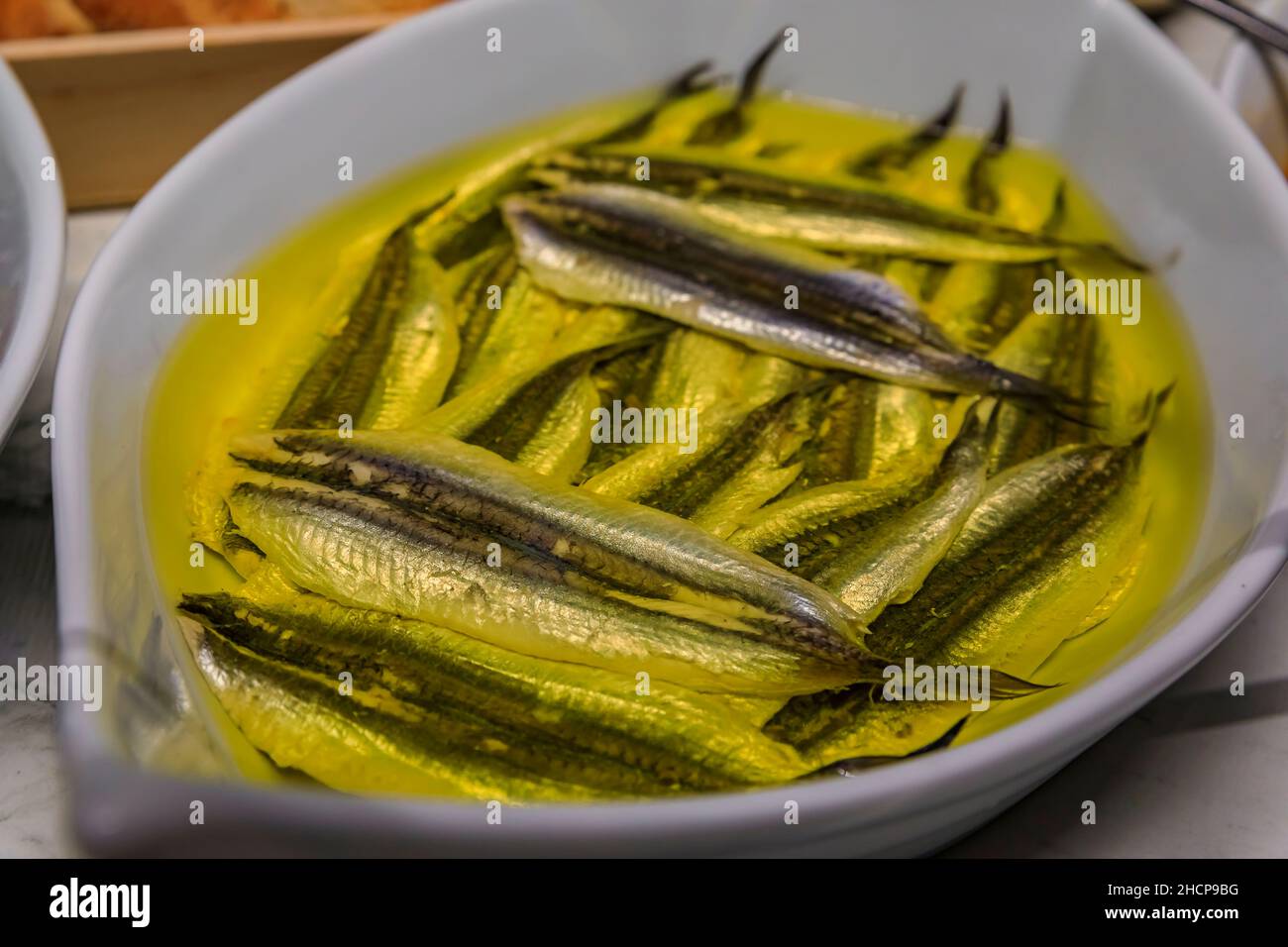 Traditional Spanish pintxos of anchovies marinated in vinegar in a dish ...