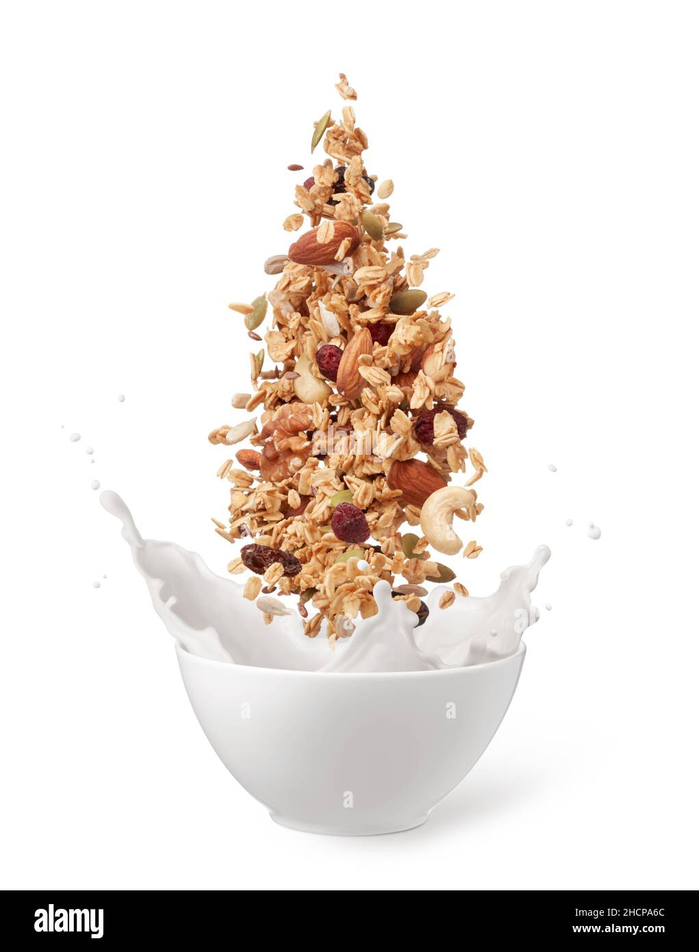 granola dropping into bowl of milk creating splash Stock Photo - Alamy