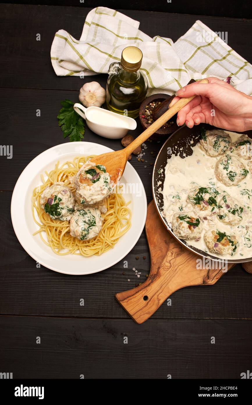 Portion of delicious meatballs with spinach in a creamy sauce Stock Photo - Alamy